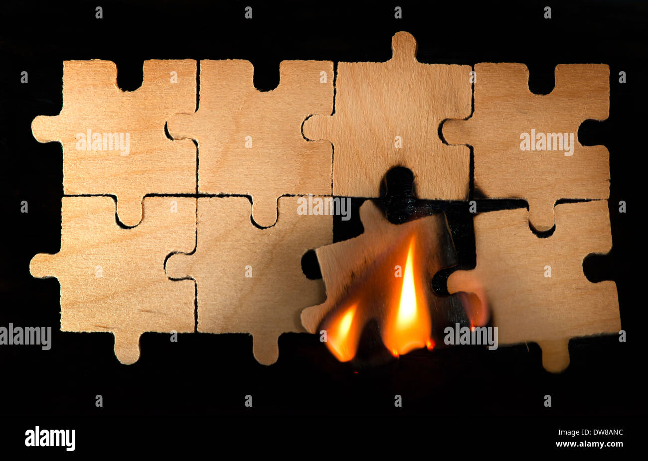Burning wooden puzzle on dark background. Close up Stock Photo - Alamy