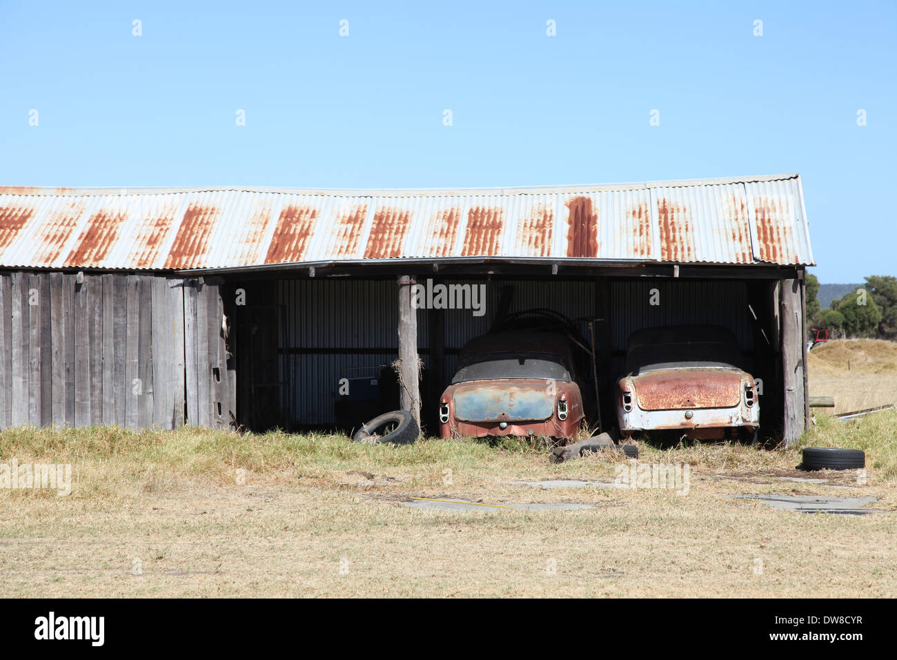 Two old cars rust in a rusty shed Stock Photo - Alamy