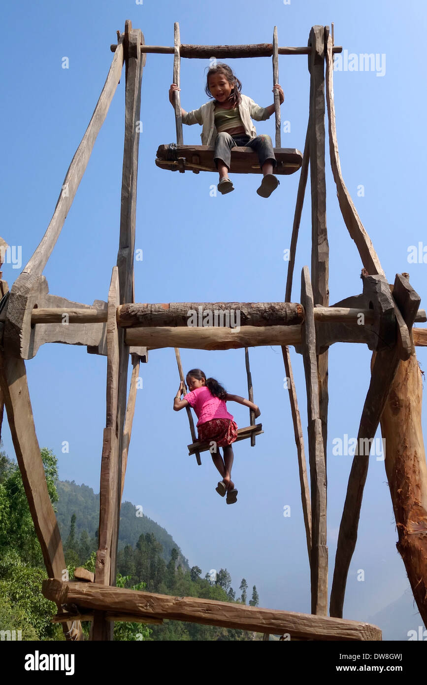 Children playing on a wooden ferris wheel in the Gorkha region of Nepal ...