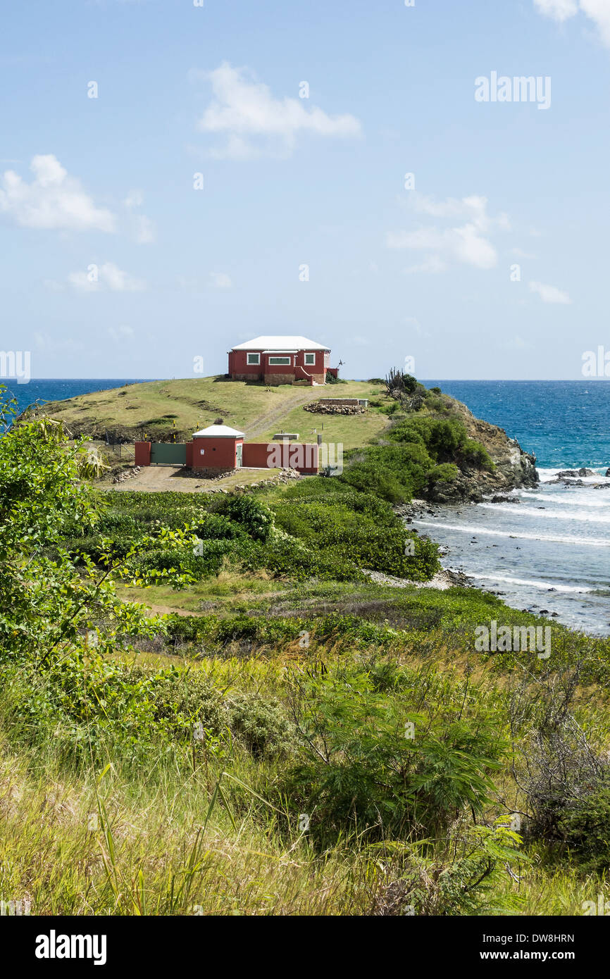 A cluster of red buildings sit on a peninsula into the Caribbean sea on ...