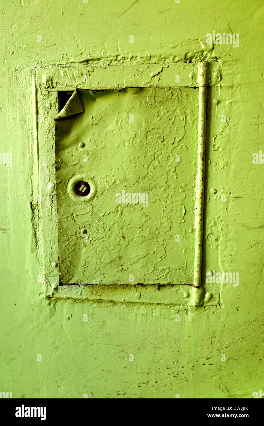 Small mysterious utility door in green wall of apartment building. Lodz ...