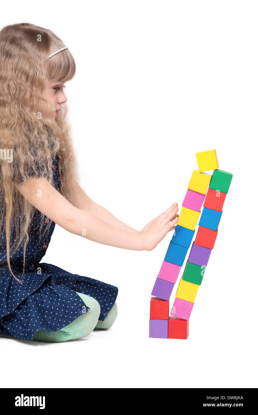 Adorable little girl push a brick toy tower isolated on white ...