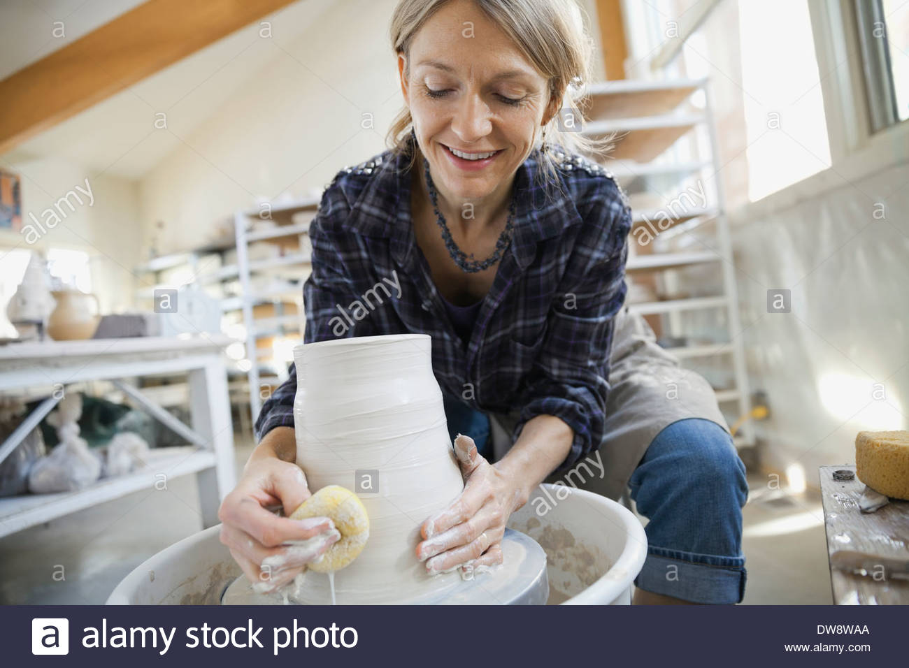 Woman pulling clay on potters wheel Stock Photo - Alamy