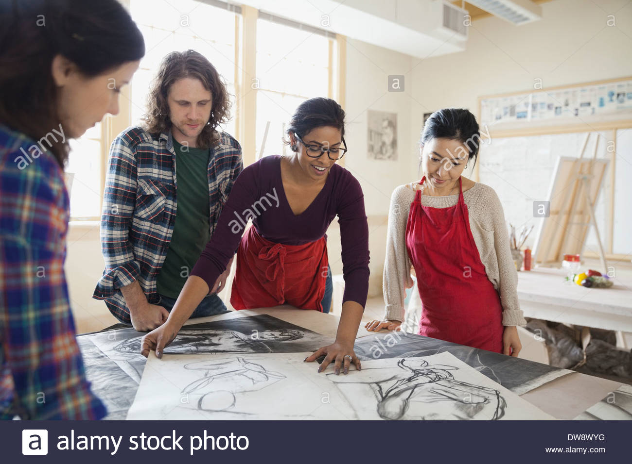 Students examining charcoal drawings in art class Stock Photo - Alamy