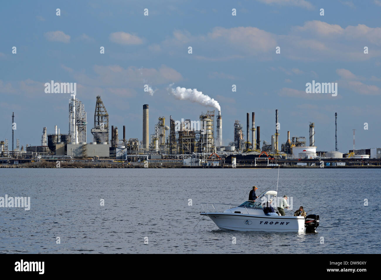 Men fishing from a pleasure boat on the Delaware River near an oil ...