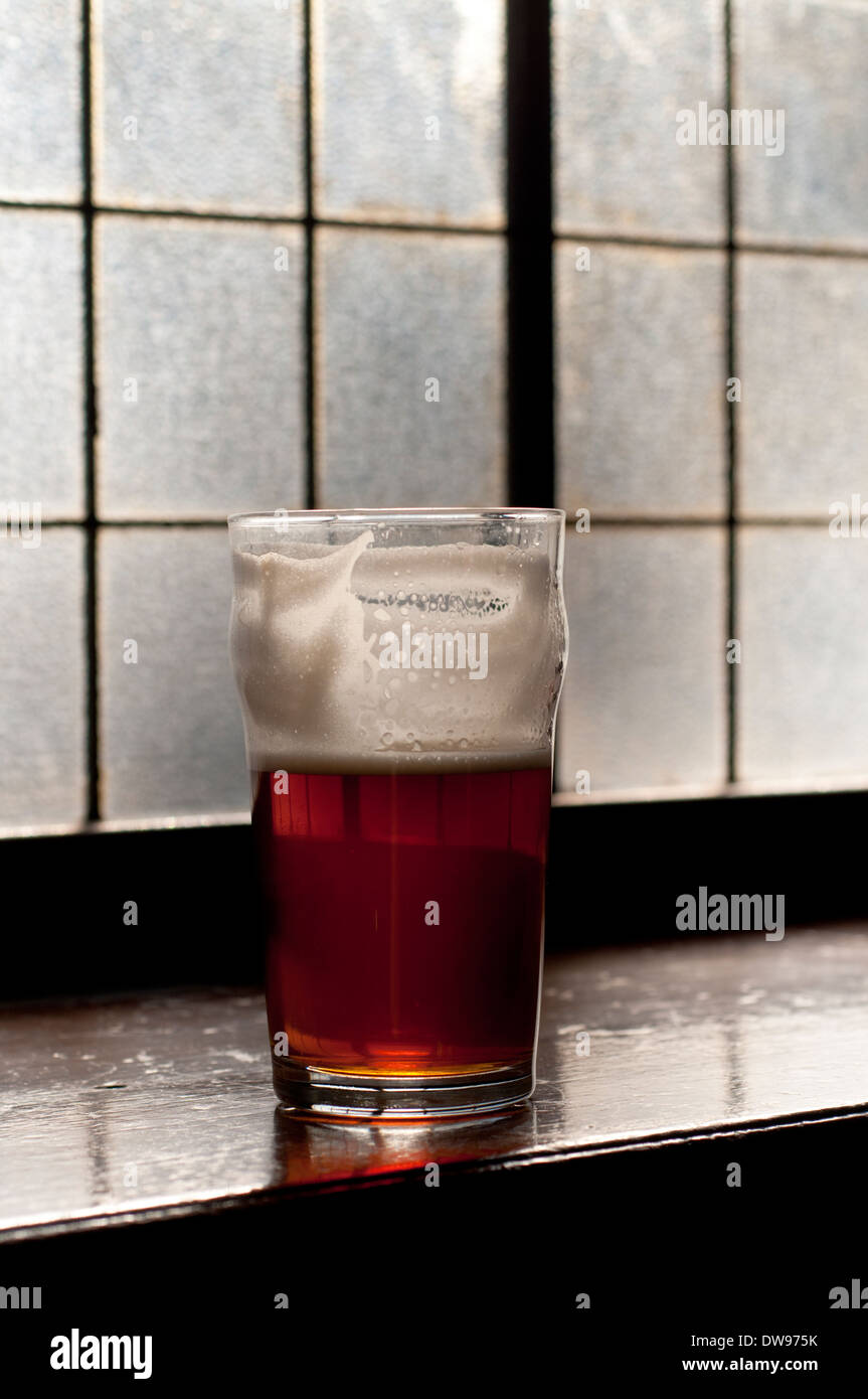A half drunk pint of English ale in a nonic glass in a pub in central ...