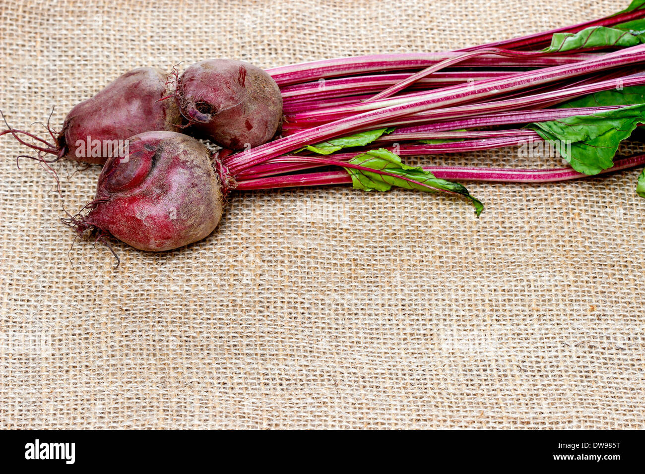 Beetroot on hessian on rustic wooden tableBeetroot on hessian on rustic ...