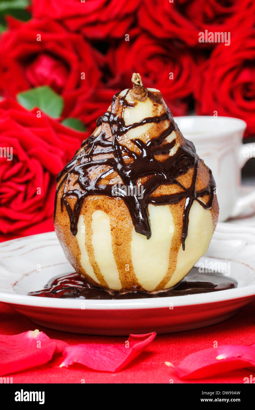 Pear with chocolate. Stunning red roses in the backgroundPear with ...