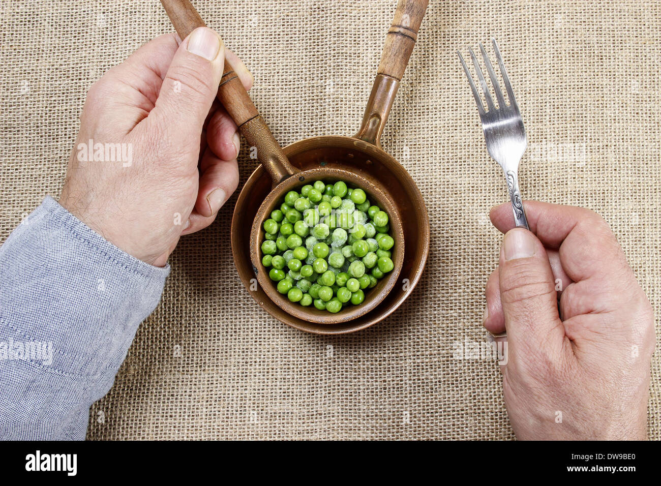 Hungry man eating green peas. Symbol of slimmingHungry man eating green ...