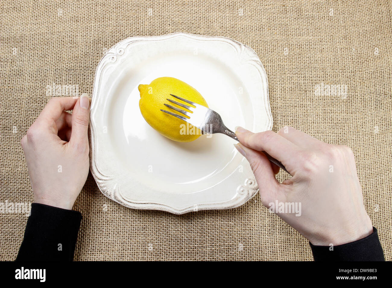 Hungry woman eating lemon. Symbol of slimmingHungry woman eating lemon ...