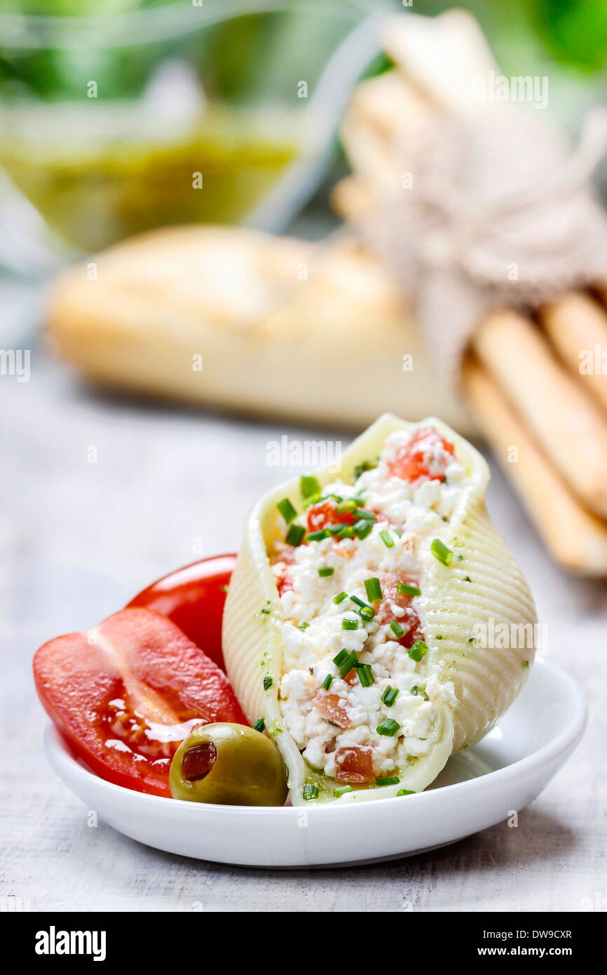 Italian cuisine: stuffed pasta shells and stack of breadsticks.Italian ...