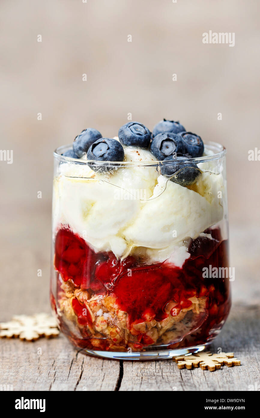 Layer strawberry, blueberry and muesli dessert in glass gobletLayer ...