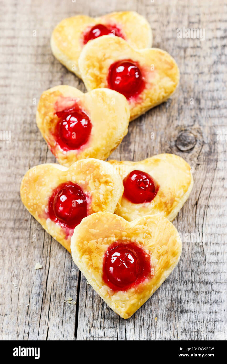 Puff pastry cookies in heart shape filled with cherriesPuff pastry ...