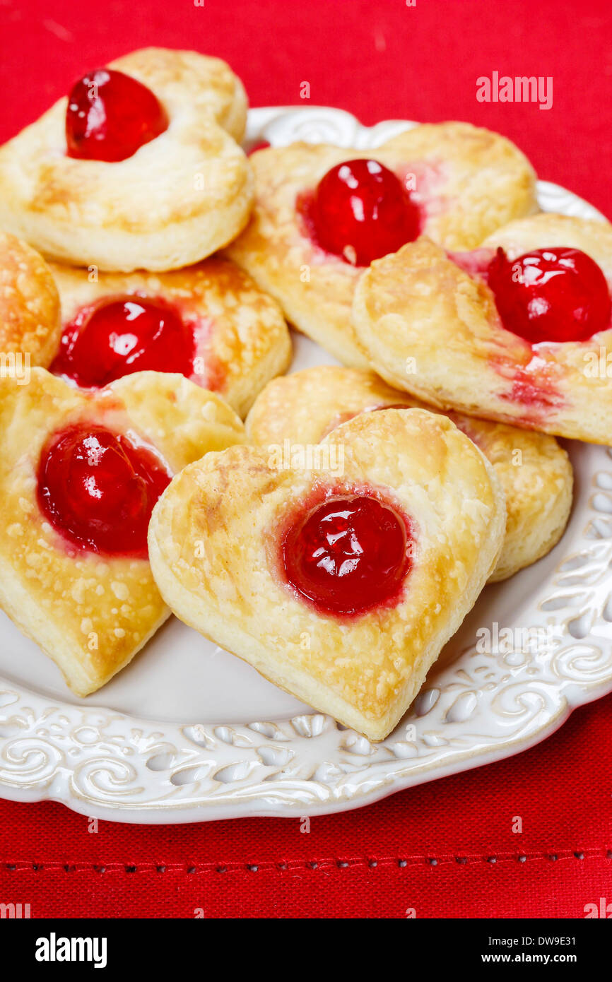 Puff pastry cookies in heart shape filled with cherriesPuff pastry ...