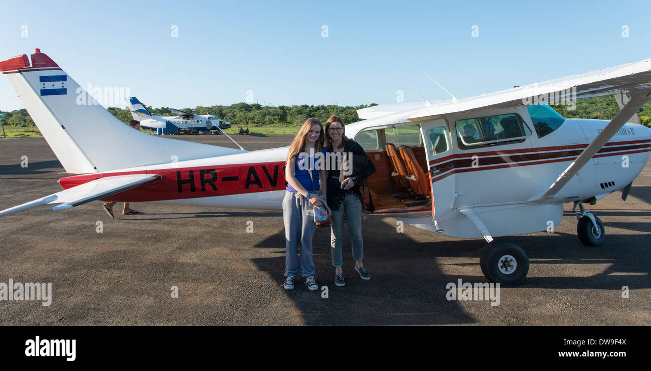 Two women standing in front of a seaplane and smiling Bay Islands ...