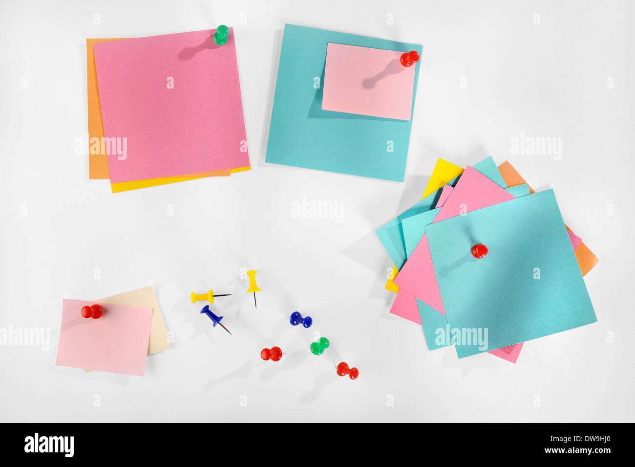 Multiple blank colorful paper notes and colorful pins on white ...
