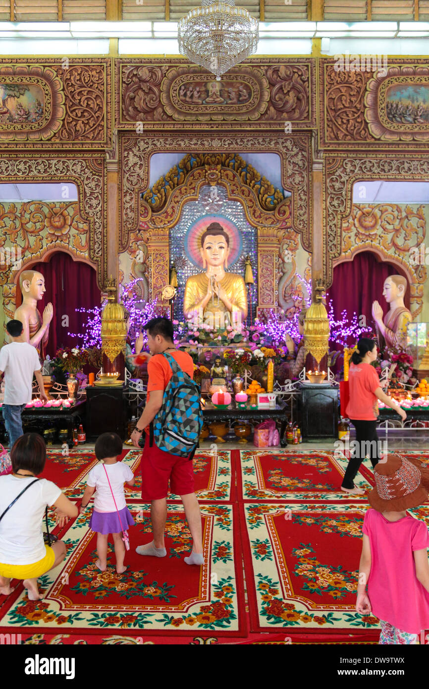 Family members praying inside the Dhammikarama, a burmese buddhist ...