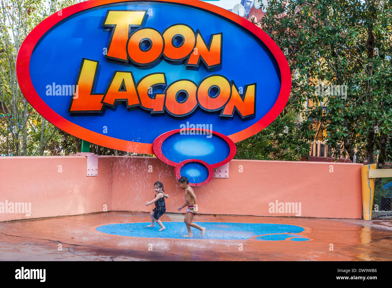 Two children playing in water jets in front of Toon Lagoon sign at ...