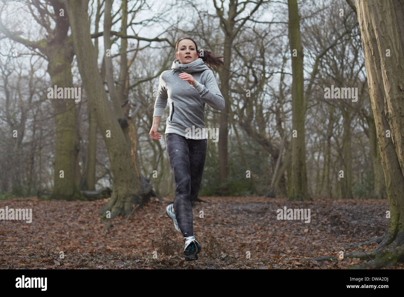 Young woman running through forest Stock Photo - Alamy