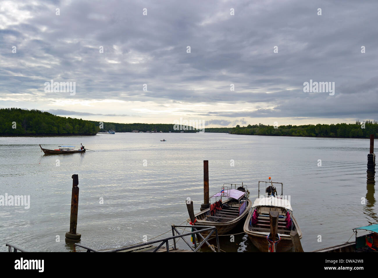 Long tailed boat and villages on Krabi River (Southern Thailand) with ...