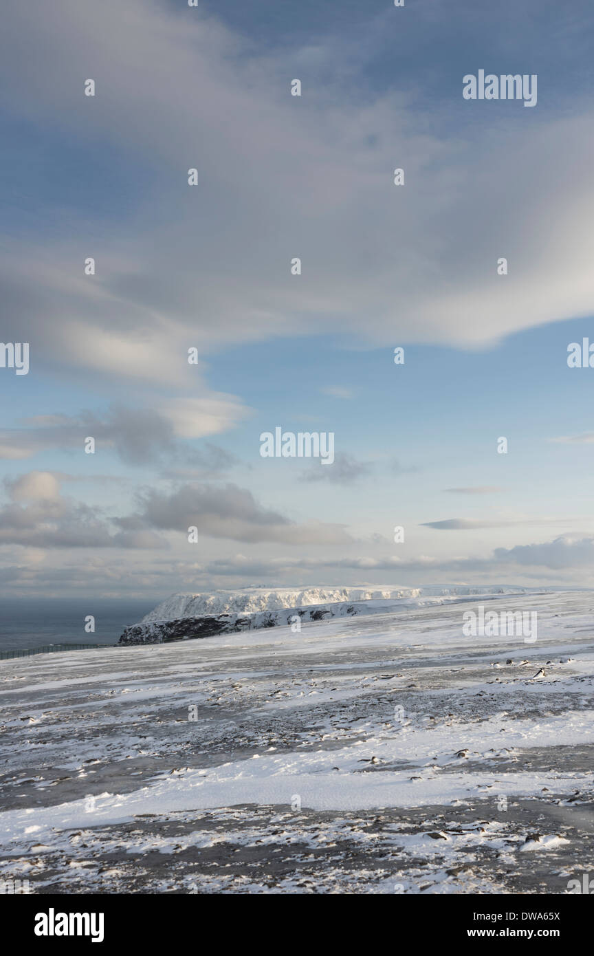A view of snowfields and cliffs back towards the island of Mageroya ...