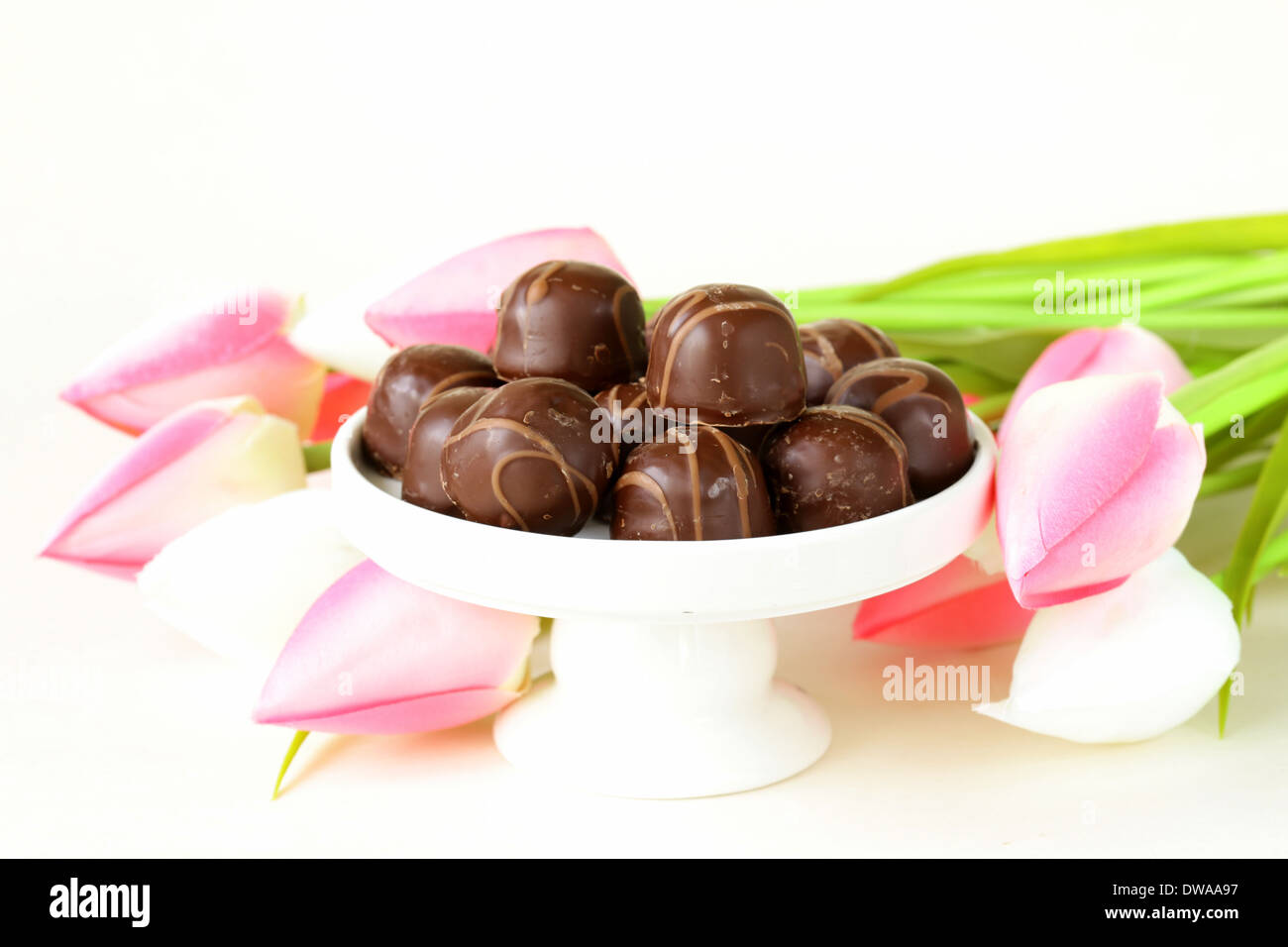 chocolate candy and flowers on white background Stock Photo - Alamy