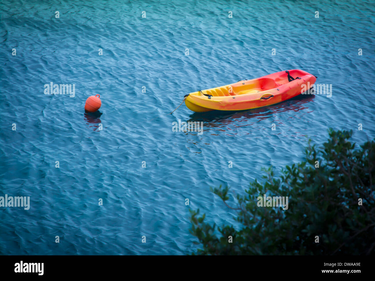 Moored yellow red plastic lifeboat in blue water. Mallorca, Balearic ...