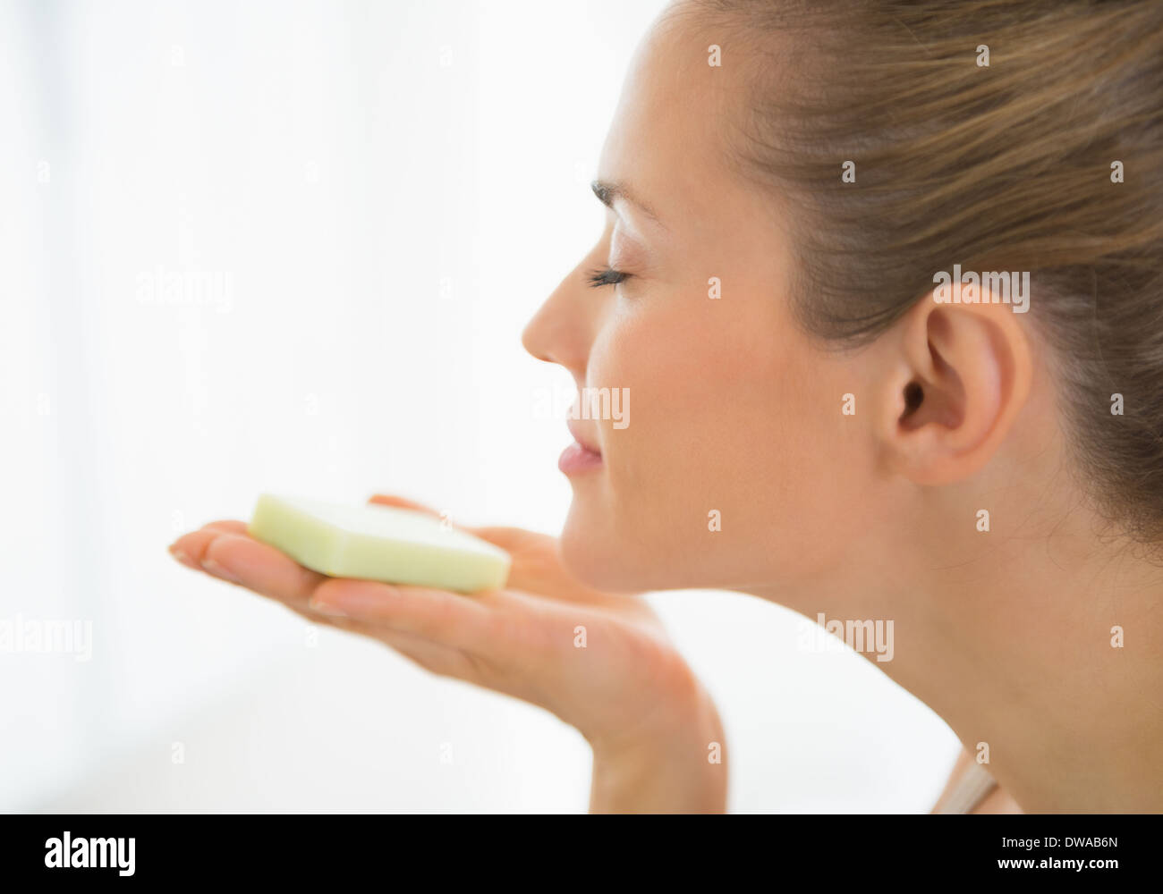Young woman smelling soap bar Stock Photo - Alamy