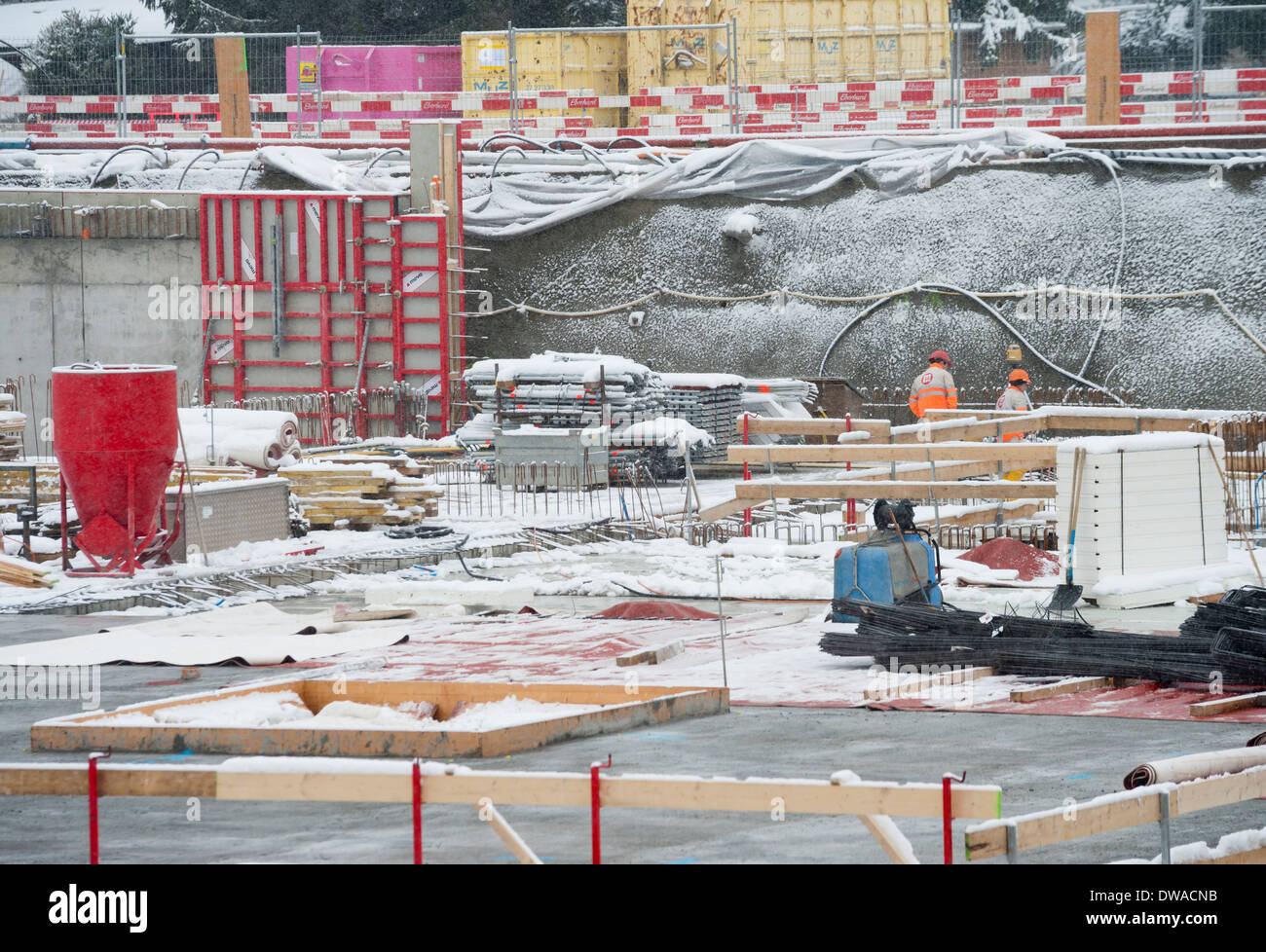 Construction workers and building activity on a snowed winter ...