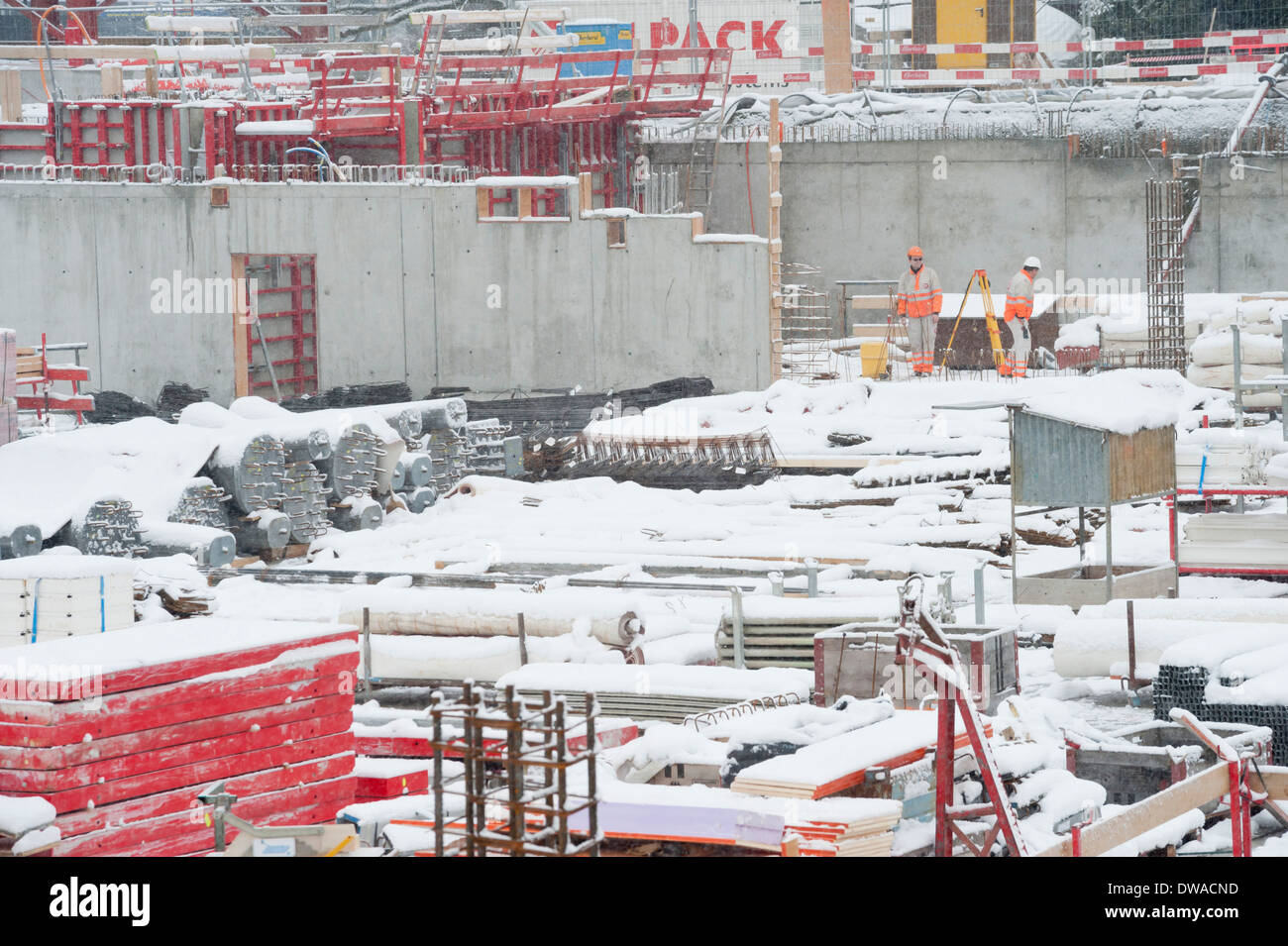 Construction workers and building activity on a snowed winter ...