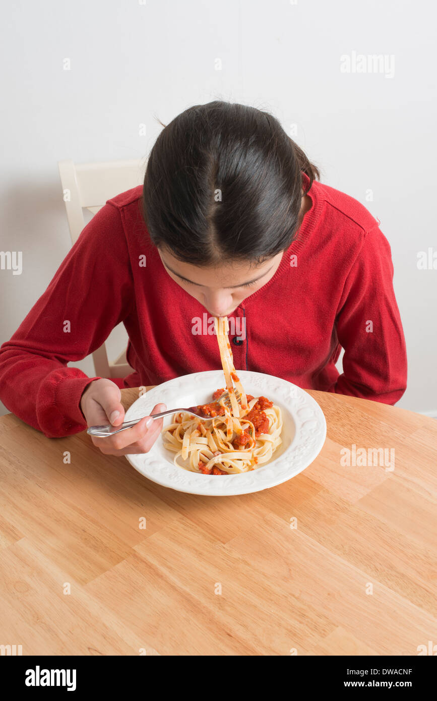 Teenage girl eating pasta Stock Photo - Alamy
