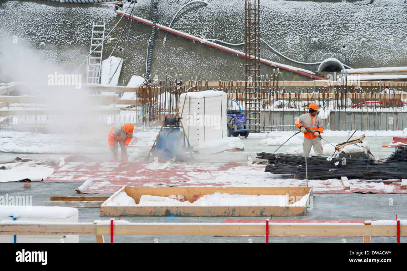 Construction workers and building activity on a snowed winter ...