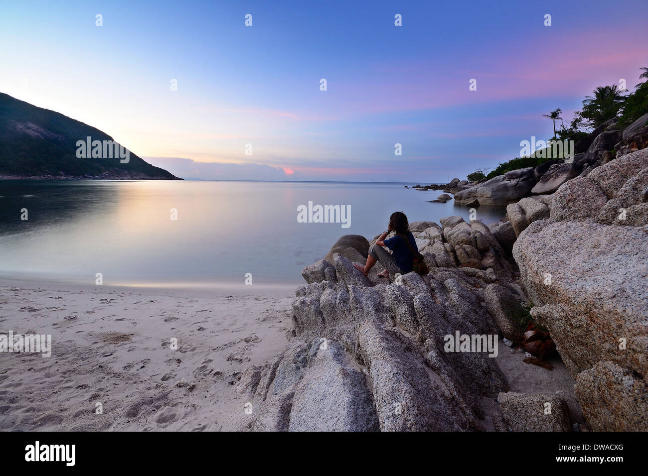 Tourist sitting on the beach and watching a breathtaking sunset at Haad ...