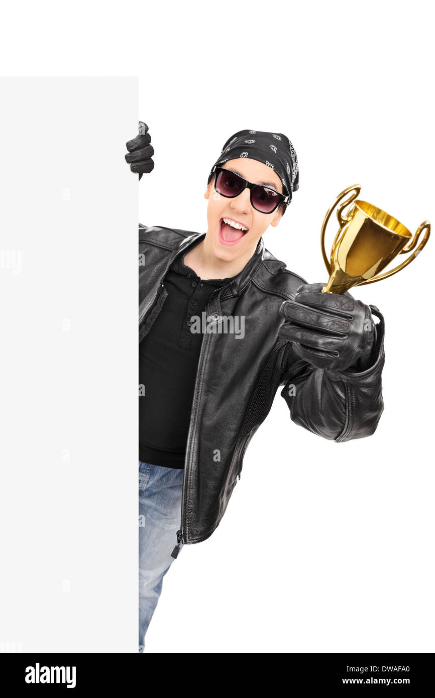 Male biker standing behind blank panel and holding a trophy Stock Photo ...