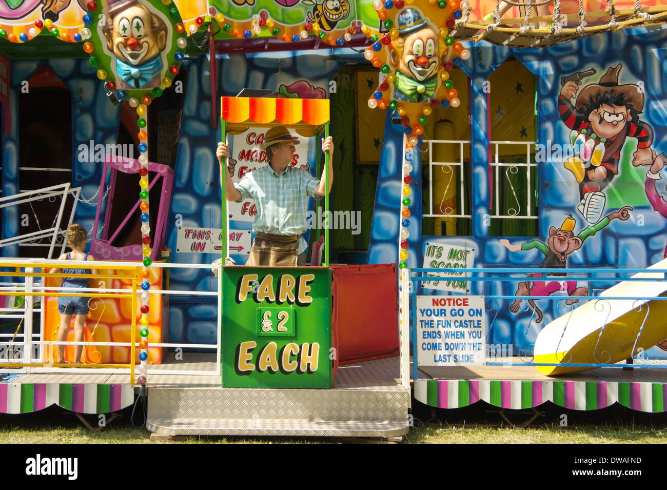 Fairground Attendant standing in a kiosk by a travelling fairground ...