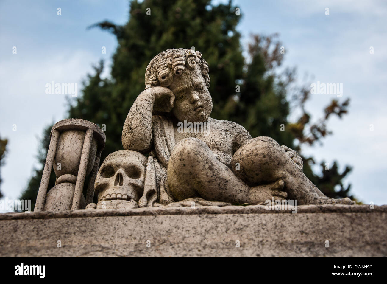 Angel resting over a skull. Statue from the top of a tomb Stock Photo ...
