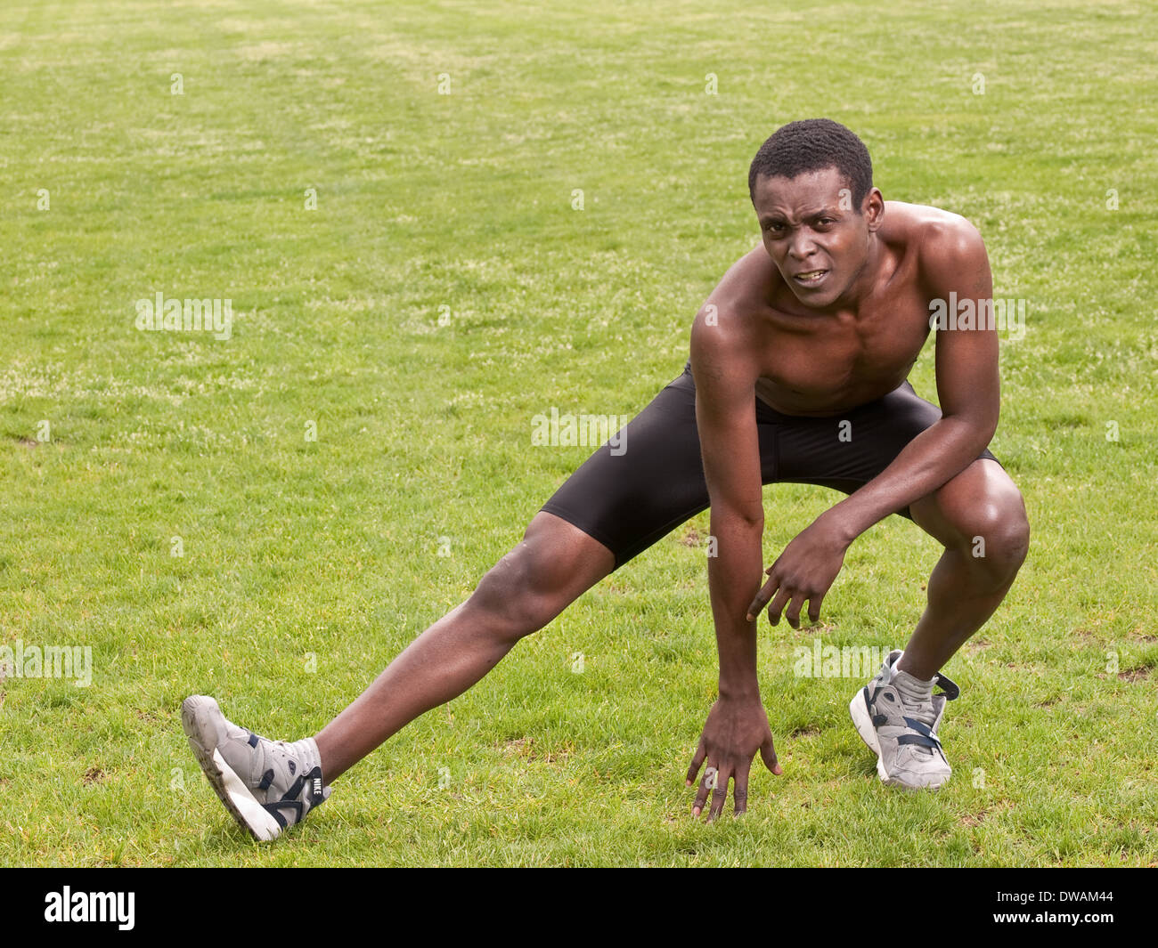 Shirtless Black male stretching on grass Stock Photo - Alamy