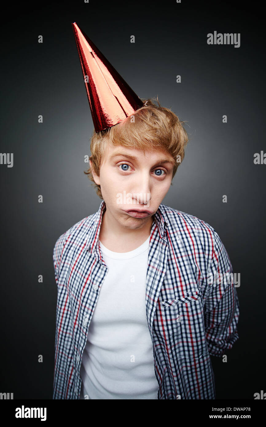 Sad guy in a cone cap being ready for fool’s day celebration looking at ...