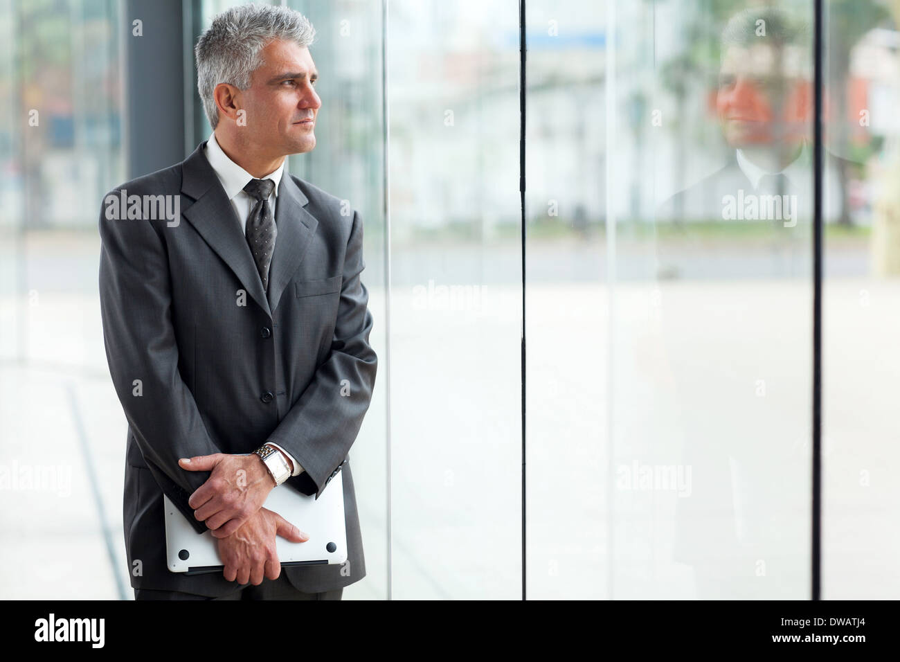 thoughtful mid age businessman looking through office window Stock ... thoughtful mid age businessman looking through office window Stock ...