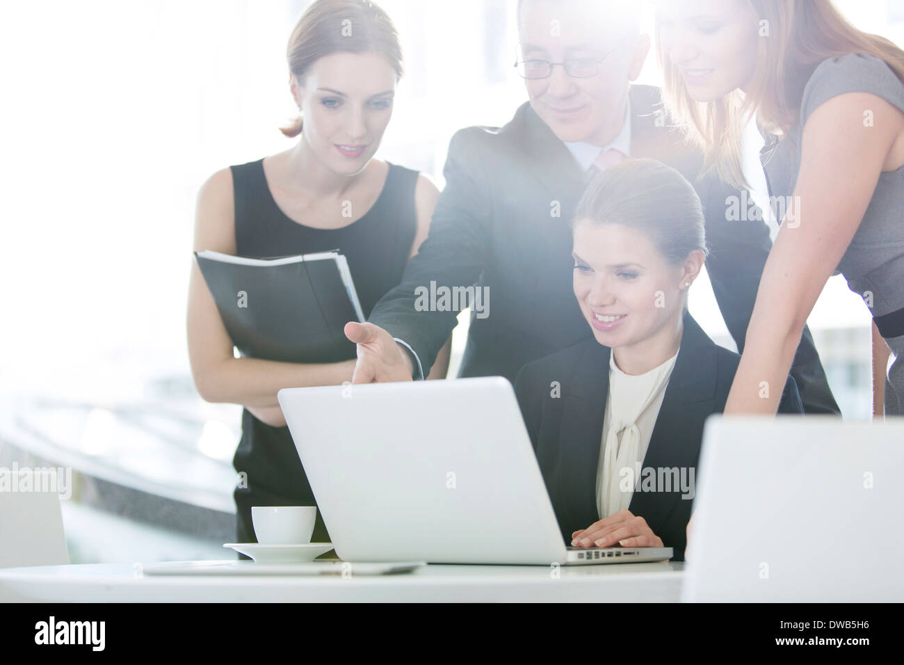Business people discussing over laptop in office cafeteria Stock Photo ...