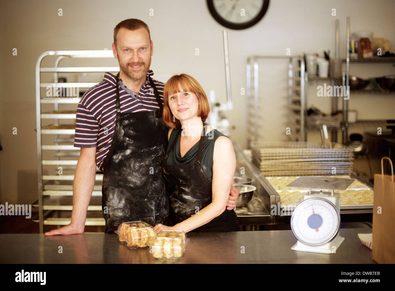 Portrait of baker couple behind kitchen counter Stock Photo - Alamy