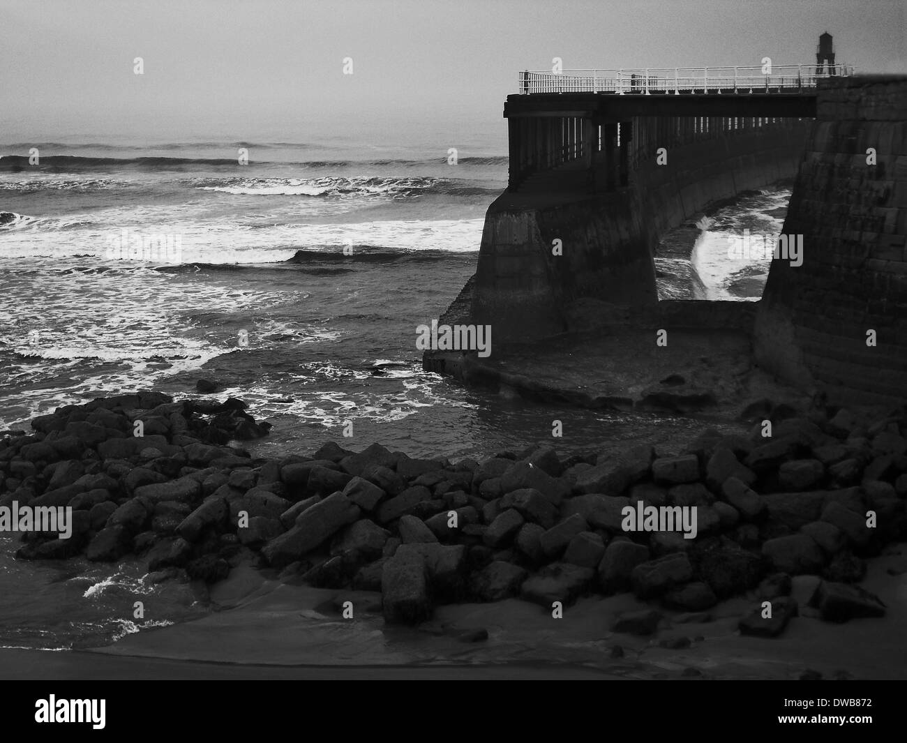 Whitby beach in black and white with rocks and pier Stock Photo - Alamy