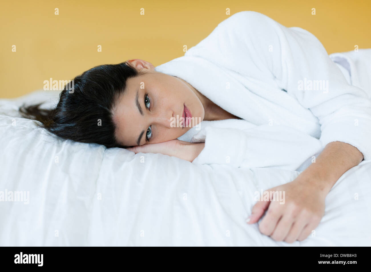 Young woman lying on bed Stock Photo - Alamy