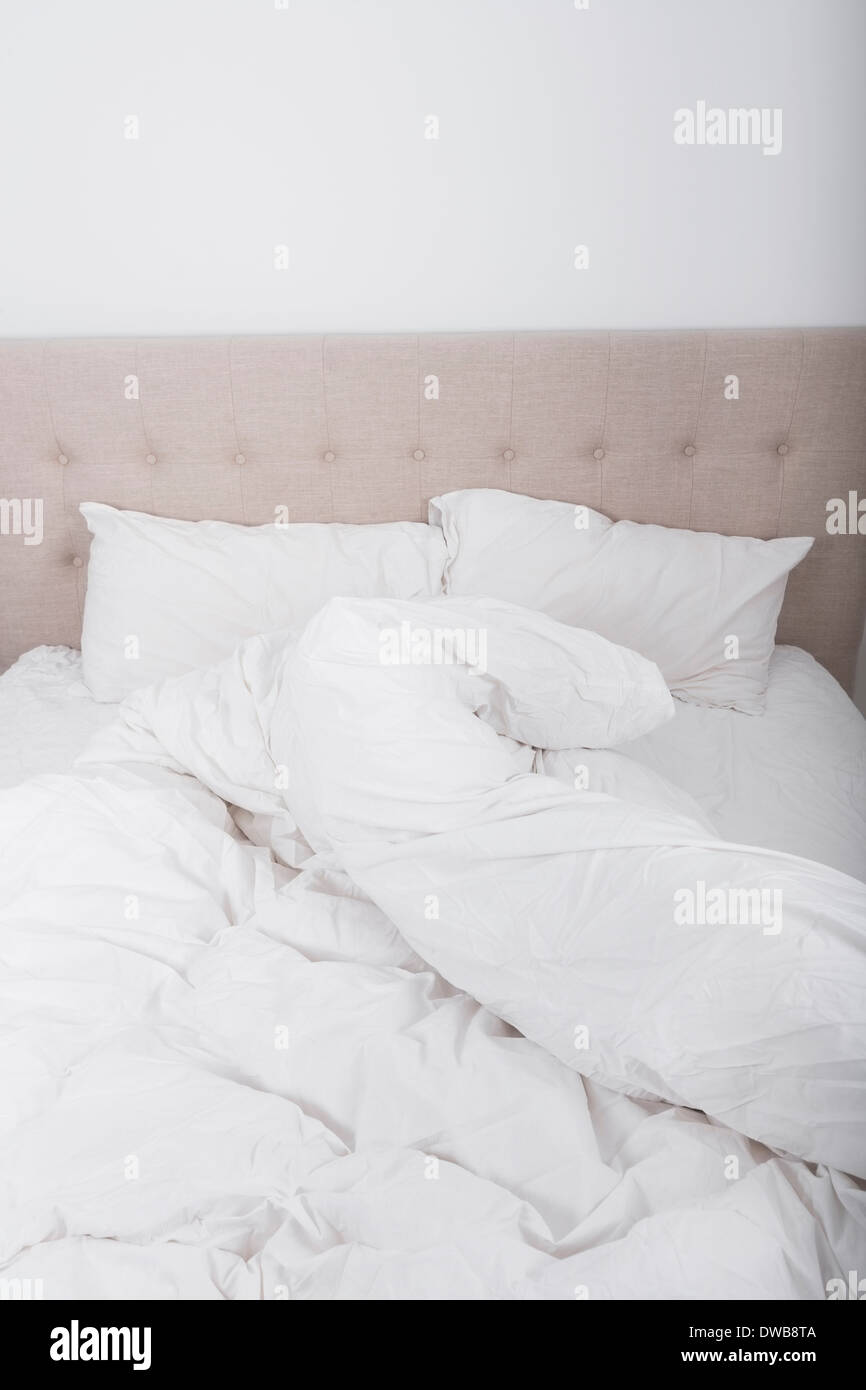 Messy bed in bedroom Stock Photo - Alamy