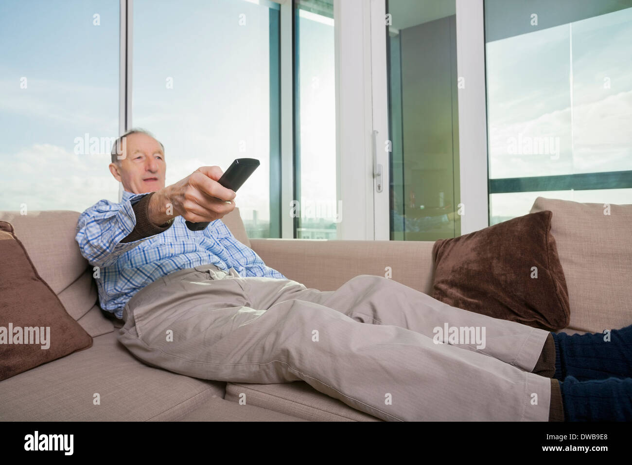 Man watching tv on sofa hi-res stock photography and images - Alamy