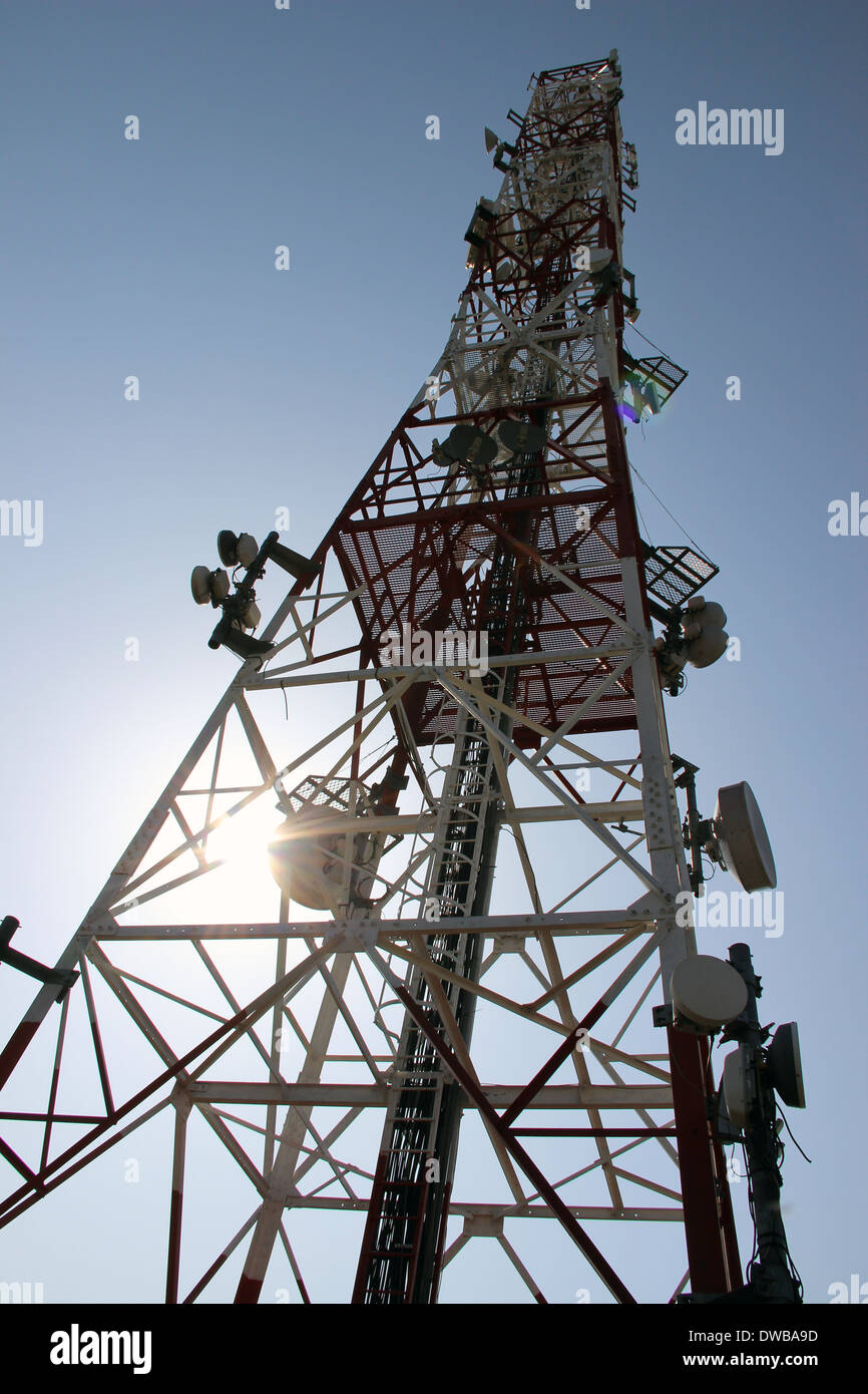 Three tall telecommunication towers with antennas on blue sky Stock Photo - Alamy