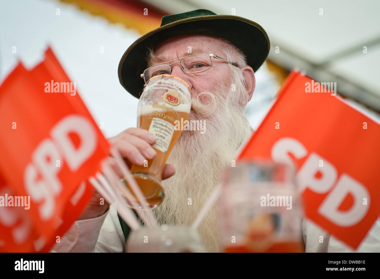 An elderly member of the SPD drinks from a glass of beer uring the ...