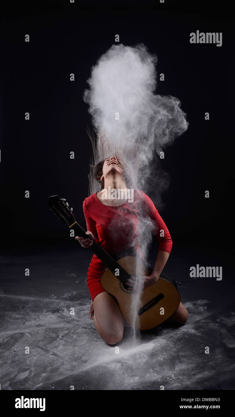Laughing young woman playing guitar Stock Photo - Alamy
