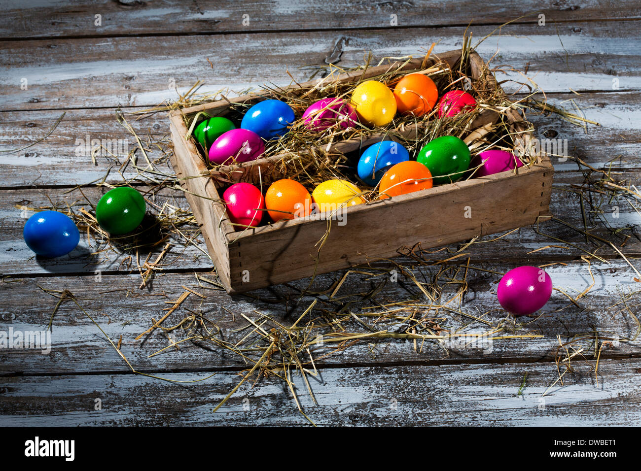 Wooden box of shiny coloured Easter eggs on wooden ground Stock Photo ...