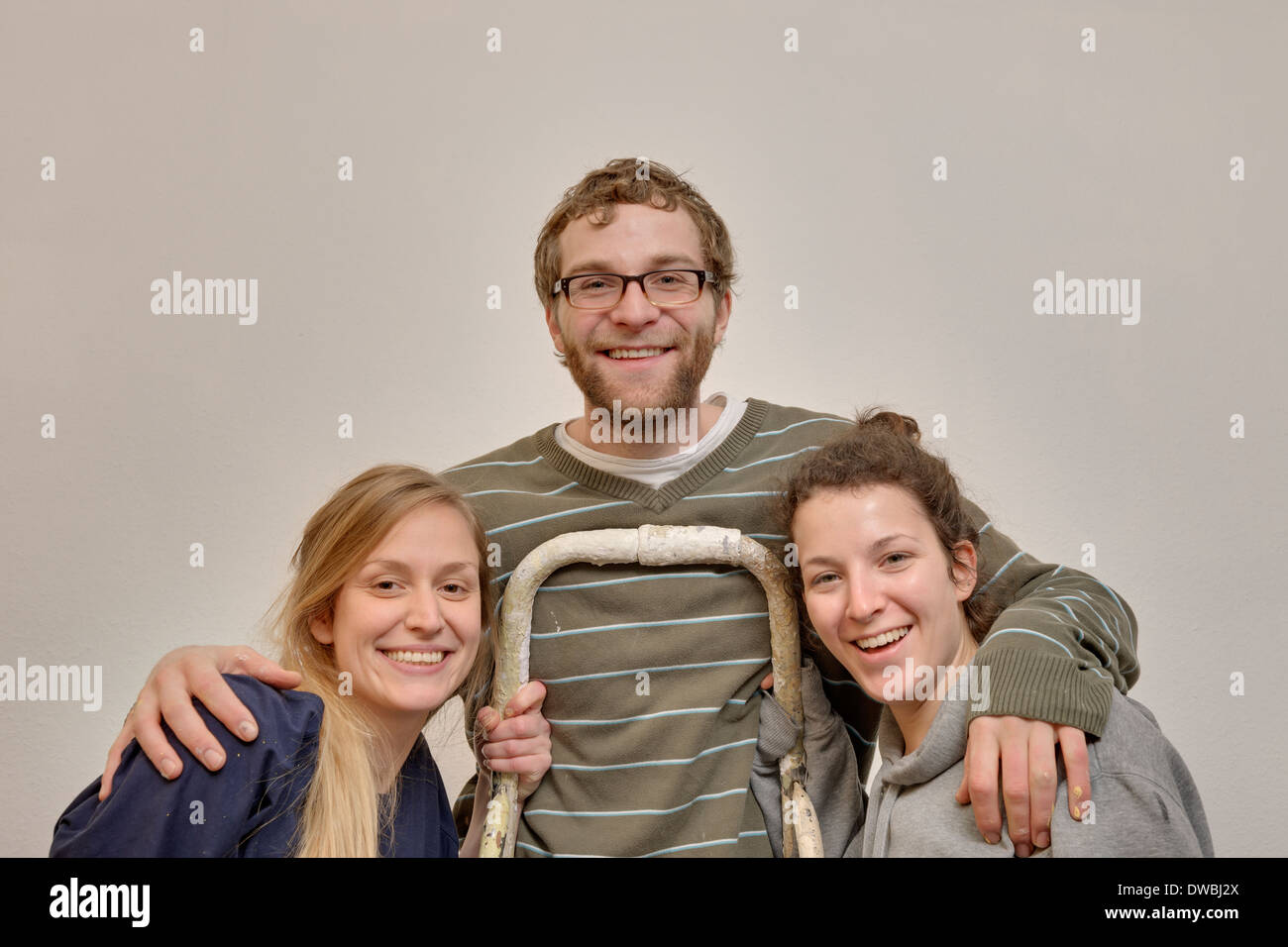 Group picture of three friends renovating apartment together Stock ...